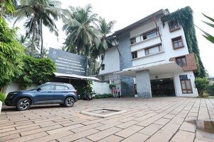 Um edifício com uma placa exibindo comodidades como restaurante, café, salão de conferências e salão de festas.