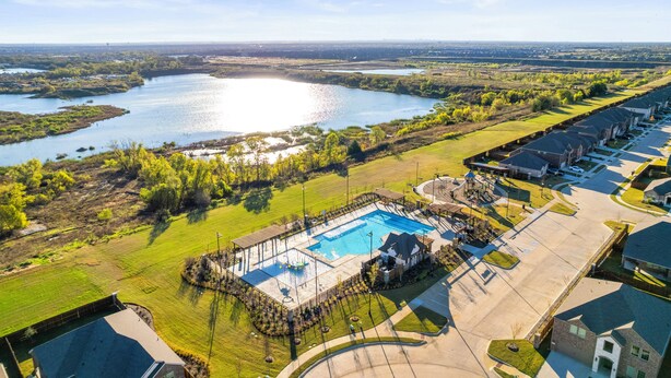 Área residencial com uma grande piscina cercada por casas e um rio.