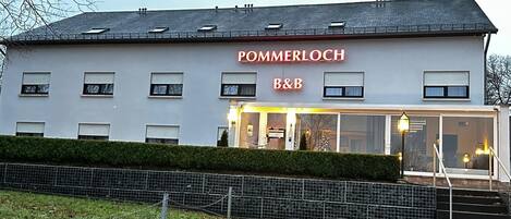 Um edifício de dois andares com uma placa indicando "POMMERLOCH B&B".