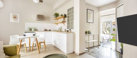 Uma sala de estar moderna com um sofá, uma mesa de centro e um espaço de jantar com cadeiras e uma mesa.