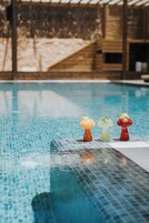 Piscina com três bebidas em copos em formato de cogumelo.