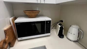 Um frigorífico/congelador grande, um micro-ondas, um forno