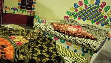 Quarto com uma cama, uma janela e uma parede com padrões coloridos.