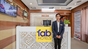 Uma receção de hotel com o letreiro 'Tab Hotels', uma televisão e um letreiro de 'Bem-vindo'.