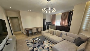 Uma sala de estar moderna com sofá, mesa de centro e área de refeições.