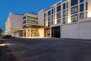 Um edifício moderno com entrada coberta e vários andares.