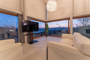 Vila panorâmica, sacada, vista para o lago | Área de estar | Smart TV 65 polegadas com canais digitais, DVD player