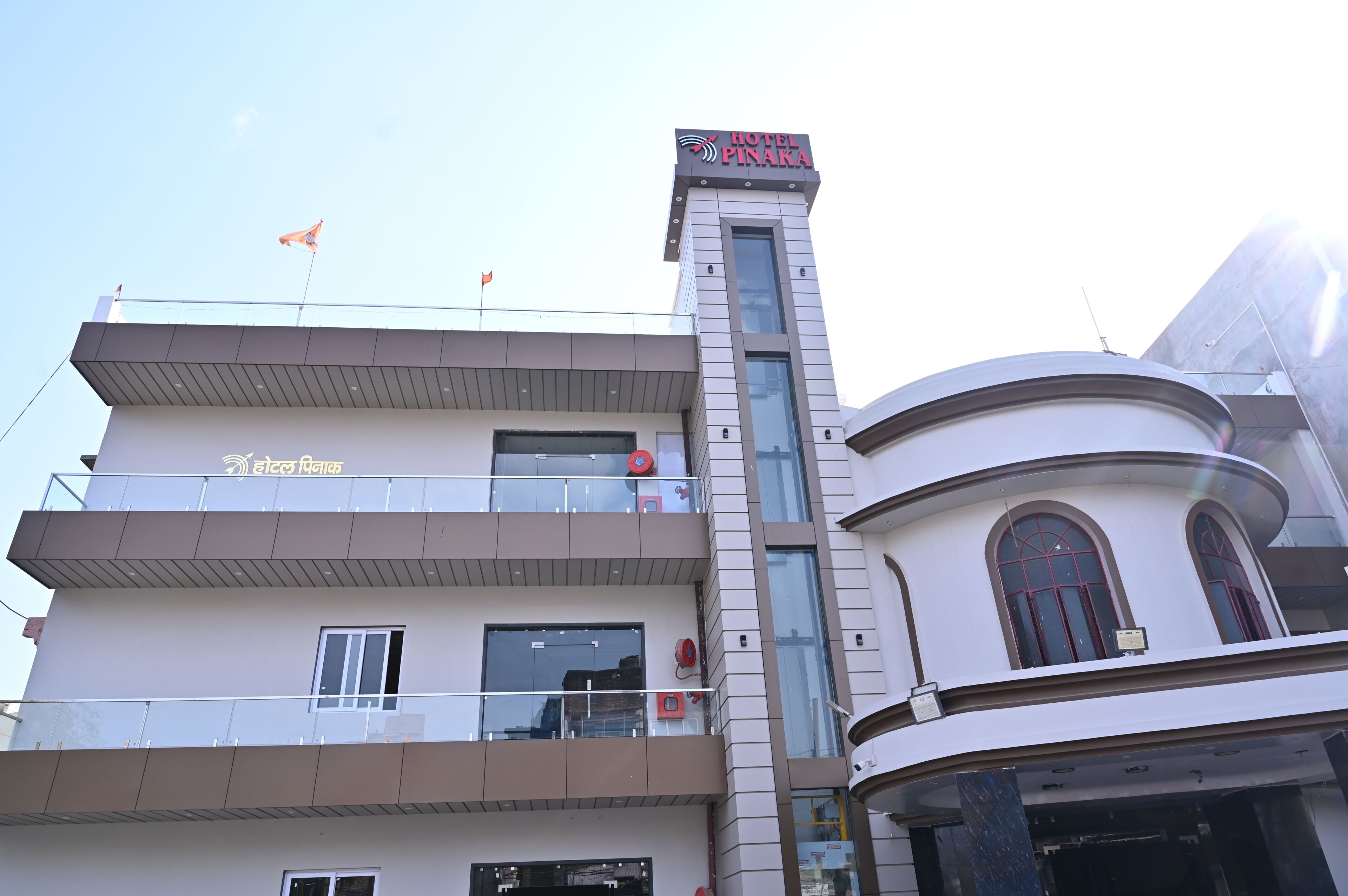 Hotel com design moderno, com uma placa em destaque, várias varandas e fachada curva.