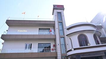 Hotel com design moderno, com uma placa em destaque, várias varandas e fachada curva.