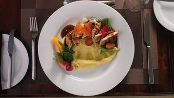 Prato de comida com diversos legumes e uma fatia de omelete em um prato branco.