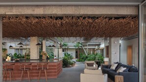 Um espaço moderno e interno com área de bar central, assentos e diversas plantas.