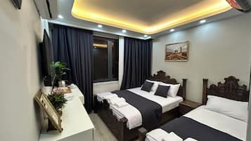 Quarto Triplo Deluxe, pátio | Secretária, secretária adequada para computadores portáteis