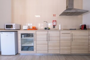 Apartamento Deluxe, 1 cama queen-size e sofá-cama, pátio, vista para o pátio | Cozinha privada | Uma cadeira de bebé 