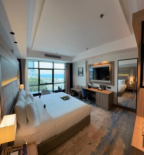 Suite Deluxe, vista parcial para o mar | Cofre no quarto, secretária adequada para computadores portáteis 