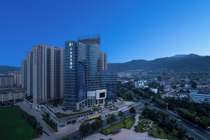Um edifício moderno de vários andares, inserido em um ambiente urbano bem cuidado.