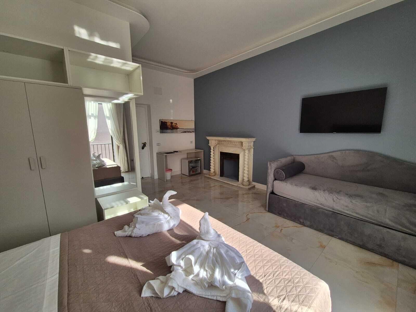 Quarto Quádruplo Comfort, vista parcial para o mar | Edredões de penas, minibar, cofre no quarto, secretária 