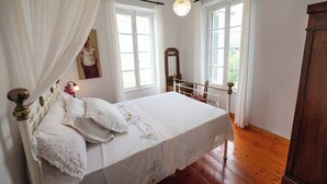 Quarto com cama, espelho e janela.