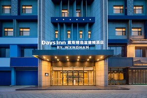 Exterior do Days Inn by Wyndham, com fachada moderna, entrada destacada e sinalização iluminada.