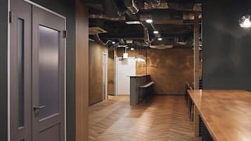 Um interior moderno com um chão de madeira em padrão herringbone, uma área de bar e um espaço de estar.