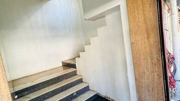 Uma escadaria com piso de mármore escuro que leva a um andar superior.