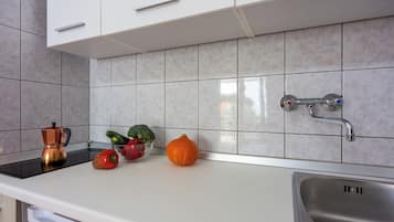 Um frigorífico, um micro-ondas, uma placa de cozinha, uma torradeira