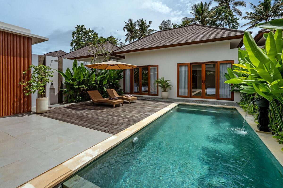Uma casa moderna com piscina, deck de madeira e espreguiçadeiras.