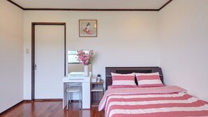 Quarto com cama, escrivaninha e cadeira.