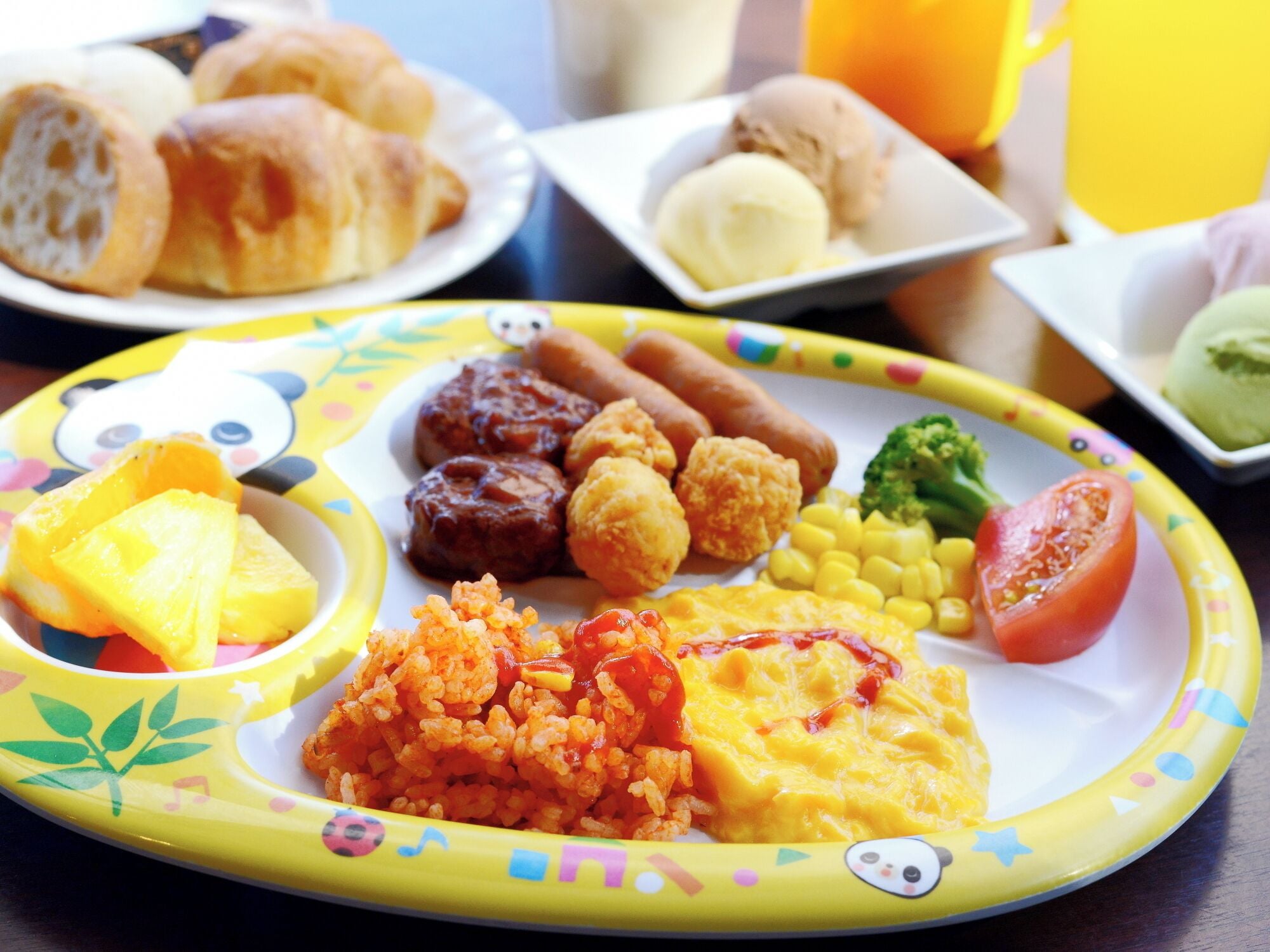 Um prato de comida com arroz, ovos, salsichas e legumes.