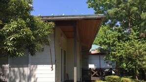 Uma casa térrea com varanda coberta, caixa de correio à vista e jardim bem cuidado.