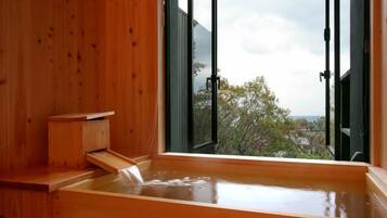 Uma sauna de madeira com vista para árvores e edifícios.