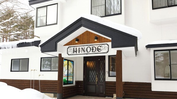 Um edifício com uma placa indicando 'HINODE' sobre a entrada.