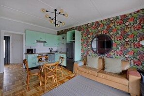 Um espaço compacto para viver, com cozinha compacta, área de refeições e sofá.