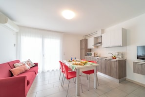 Apartamento moderno com área de refeições, cozinha e sala de estar.
