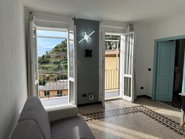 Suíte panorâmica, várias camas, sacada, vista para o mar | Área de estar | TV LED 32 polegadas com canais a cabo