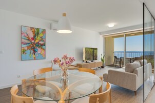 Apartamento Deluxe, vista para o mar | Sala de estar | Televisor de ecrã plano de 35 polegadas com canais por cabo 