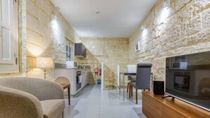 Um espaço compacto com cozinha compacta, área de refeições e sala de estar com televisão.