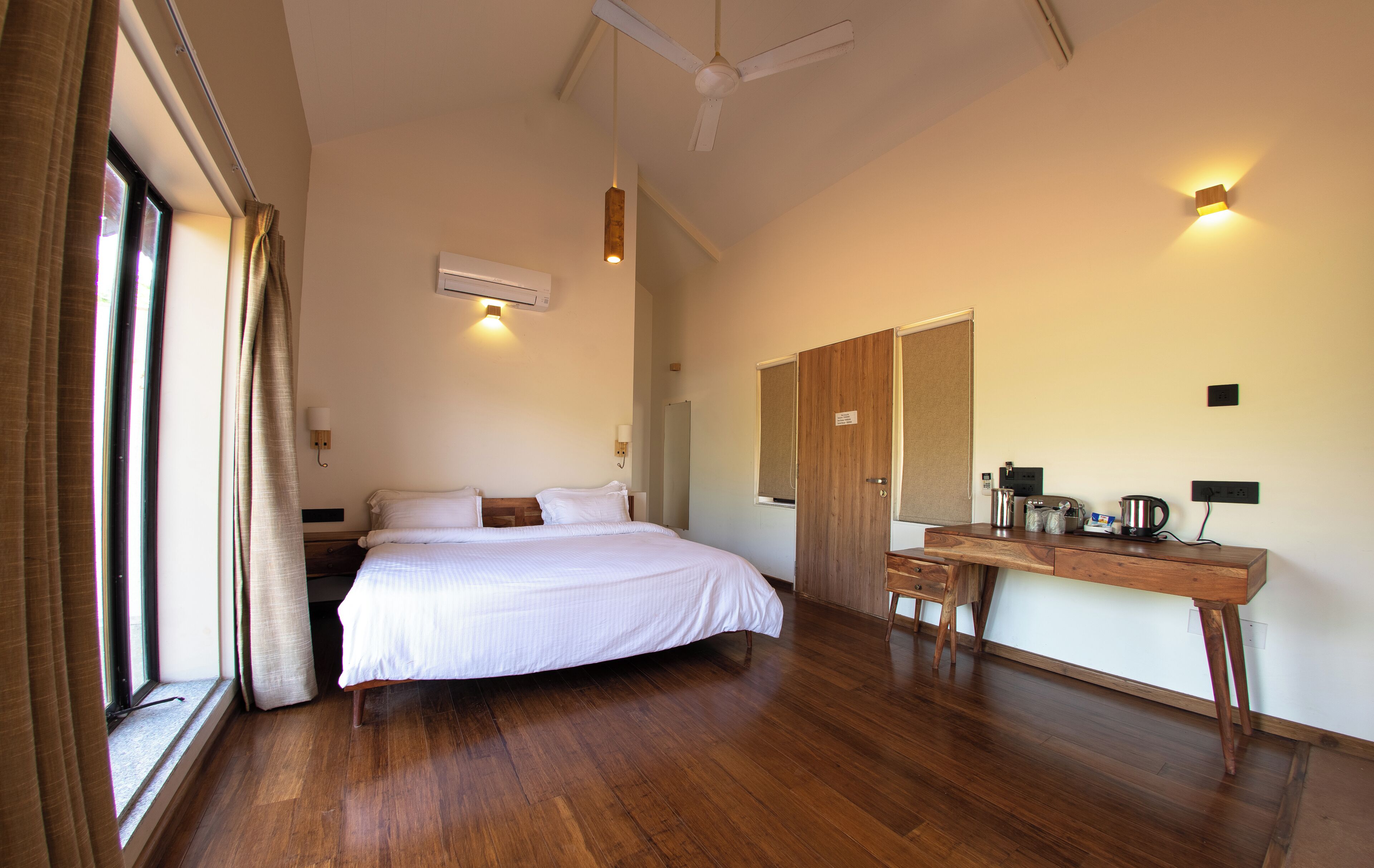 Quarto com cama, escrivaninha de madeira e guarda-roupa.