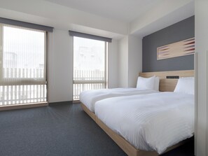 Quarto de hotel com uma cama grande, duas janelas com persianas, uma cabeceira com painel de controle e um quadro na parede.