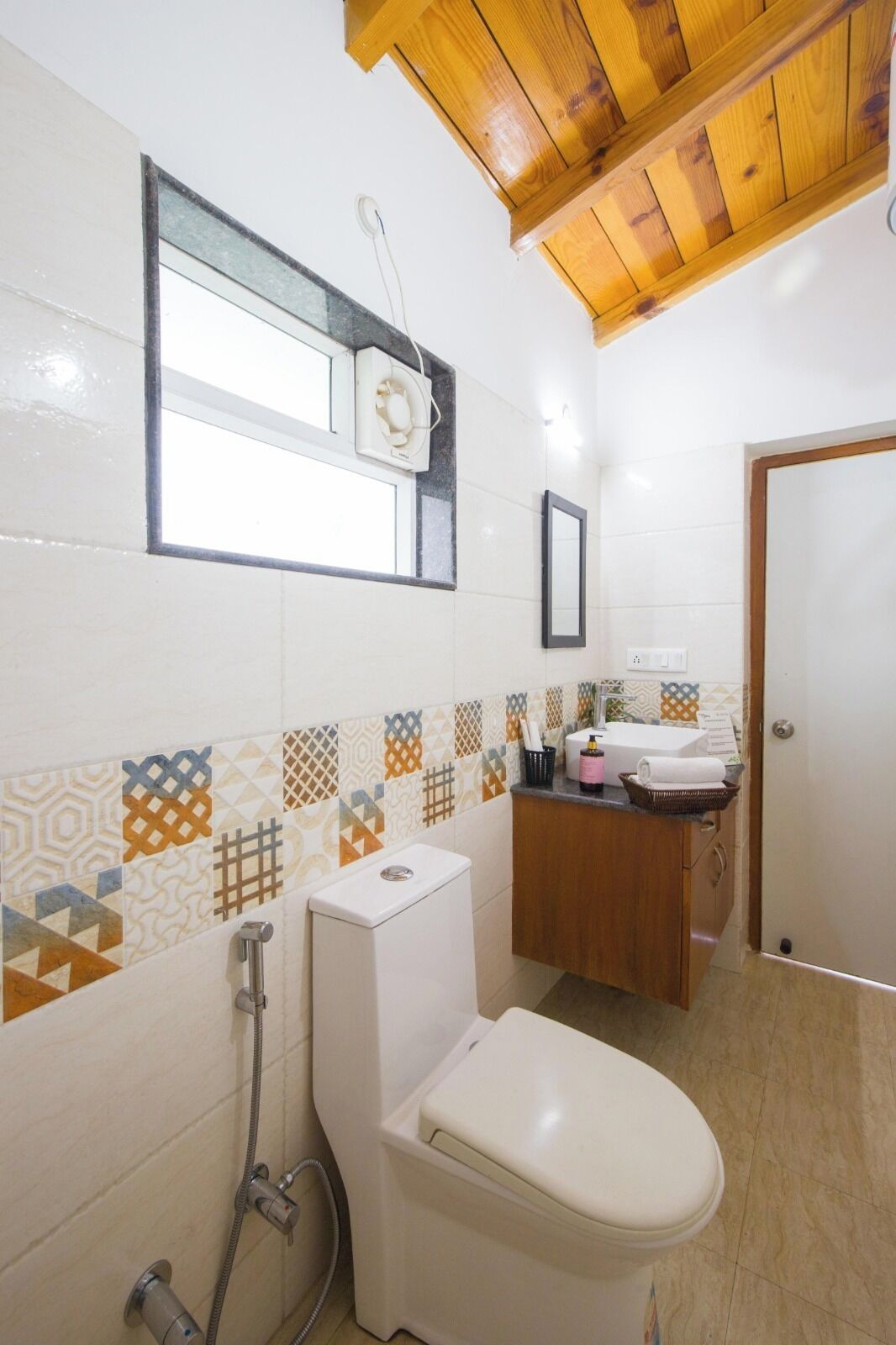 Casa de banho com sanita, chuveiro e lavatório.