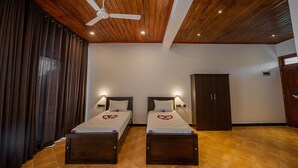 Quarto com duas camas, teto de madeira e um guarda-roupa.
