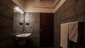 Uma casa de banho com lavatório, espelho e porta-toalhas.