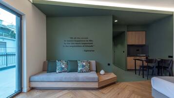 Uma sala de estar moderna com um sofá, uma citação na parede e vista para o exterior.