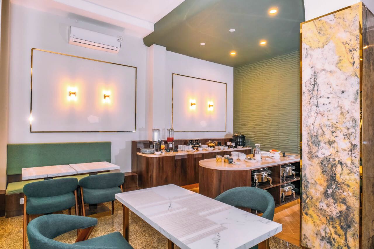 Uma área de refeições moderna com um bar, opções de assento e uma parede decorada com mármore.