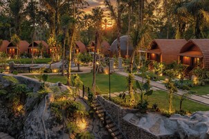 Resort com várias acomodações tipo bangalô, um caminho central e um jardim paisagístico.