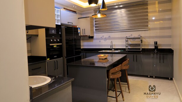 Uma cozinha moderna com ilha central, eletrodomésticos de aço inoxidável e design contemporâneo.