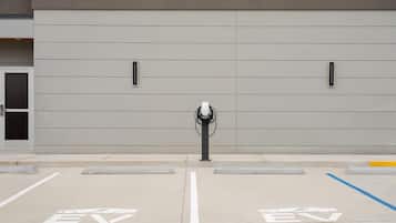 Uma área de estacionamento com estações de carregamento para veículos elétricos e vagas designadas para veículos elétricos.