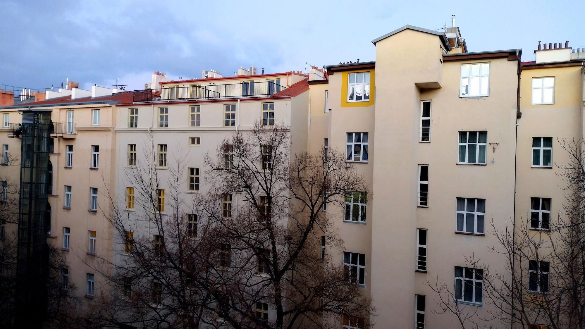 Um edifício residencial com vários andares, varandas, um telhado plano e diferentes estilos de janelas.