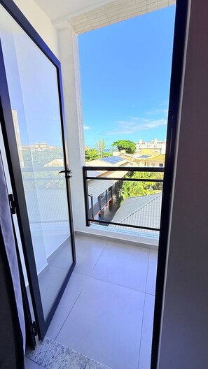 Varanda aberta com vista desobstruída para edifícios e áreas verdes.