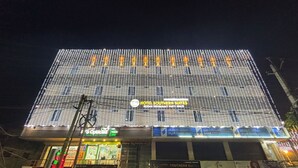 Um hotel com fachada grande e iluminada à noite, com várias janelas e um letreiro central para 'Hotel Southern Suites'.