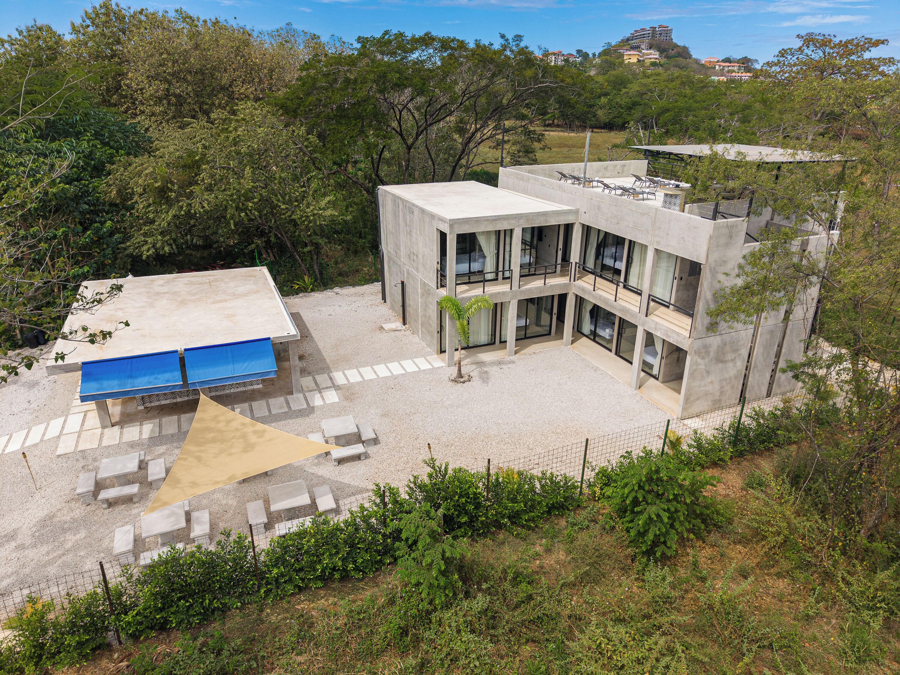 Um edifício moderno com um pátio, área de estar externa e zona de piscina.